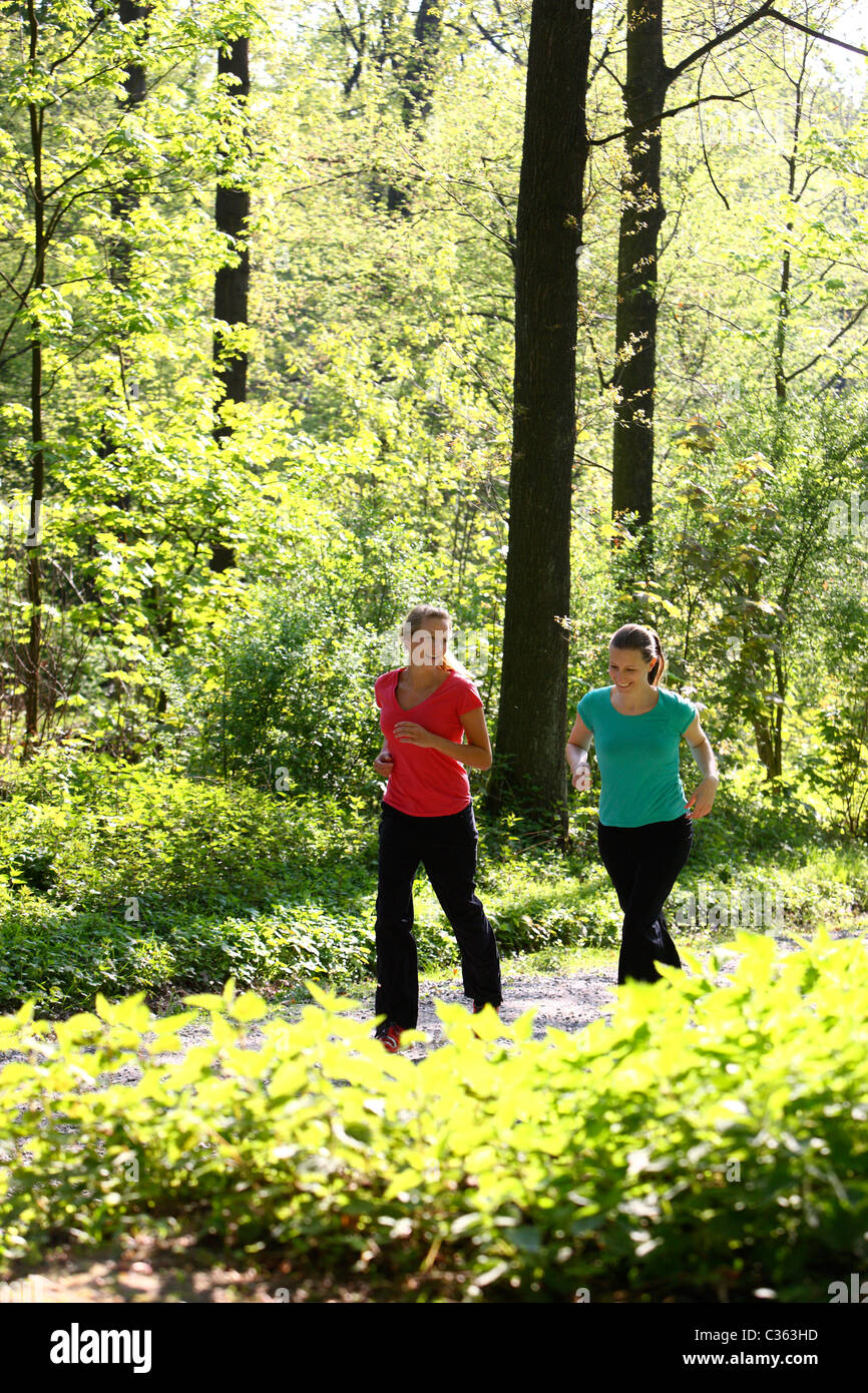 Two female hobby runners, jogging in a forest in summer Stock Photo - Alamy