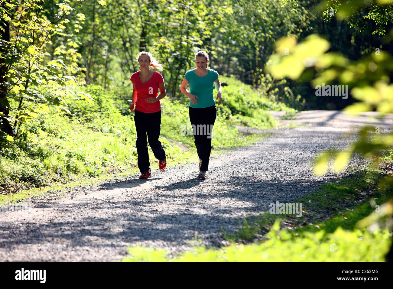 Two female hobby runners, jogging in a forest in summer Stock Photo - Alamy