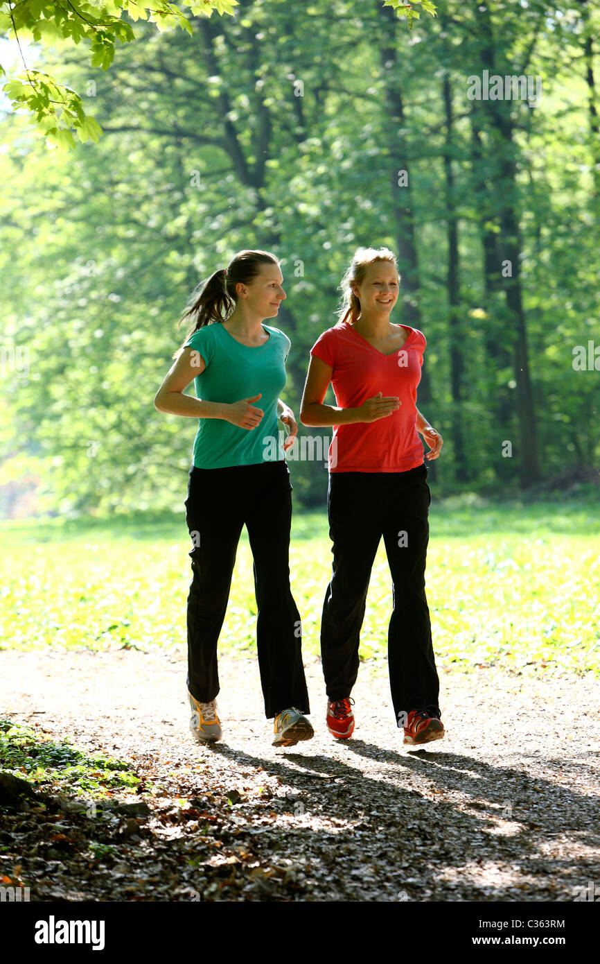 Two female hobby runners, jogging in a forest in summer Stock Photo - Alamy