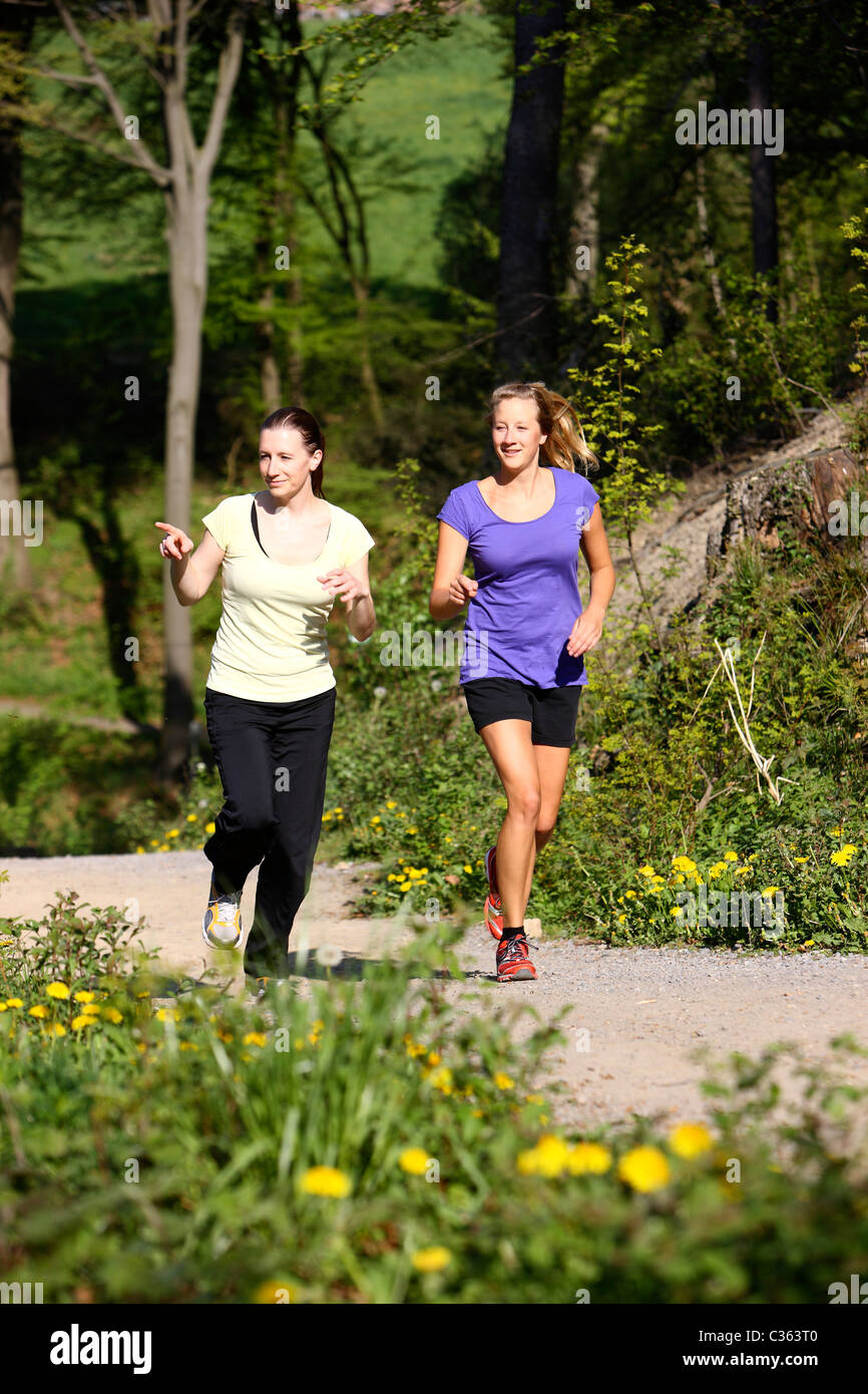 Two female hobby runners, jogging in a forest in summer Stock Photo - Alamy
