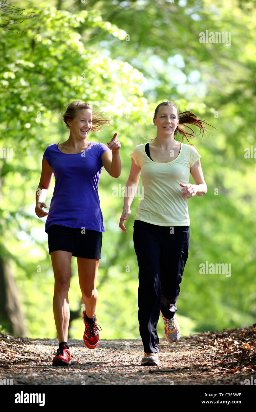 Two female hobby runners, jogging in a forest in summer Stock Photo - Alamy