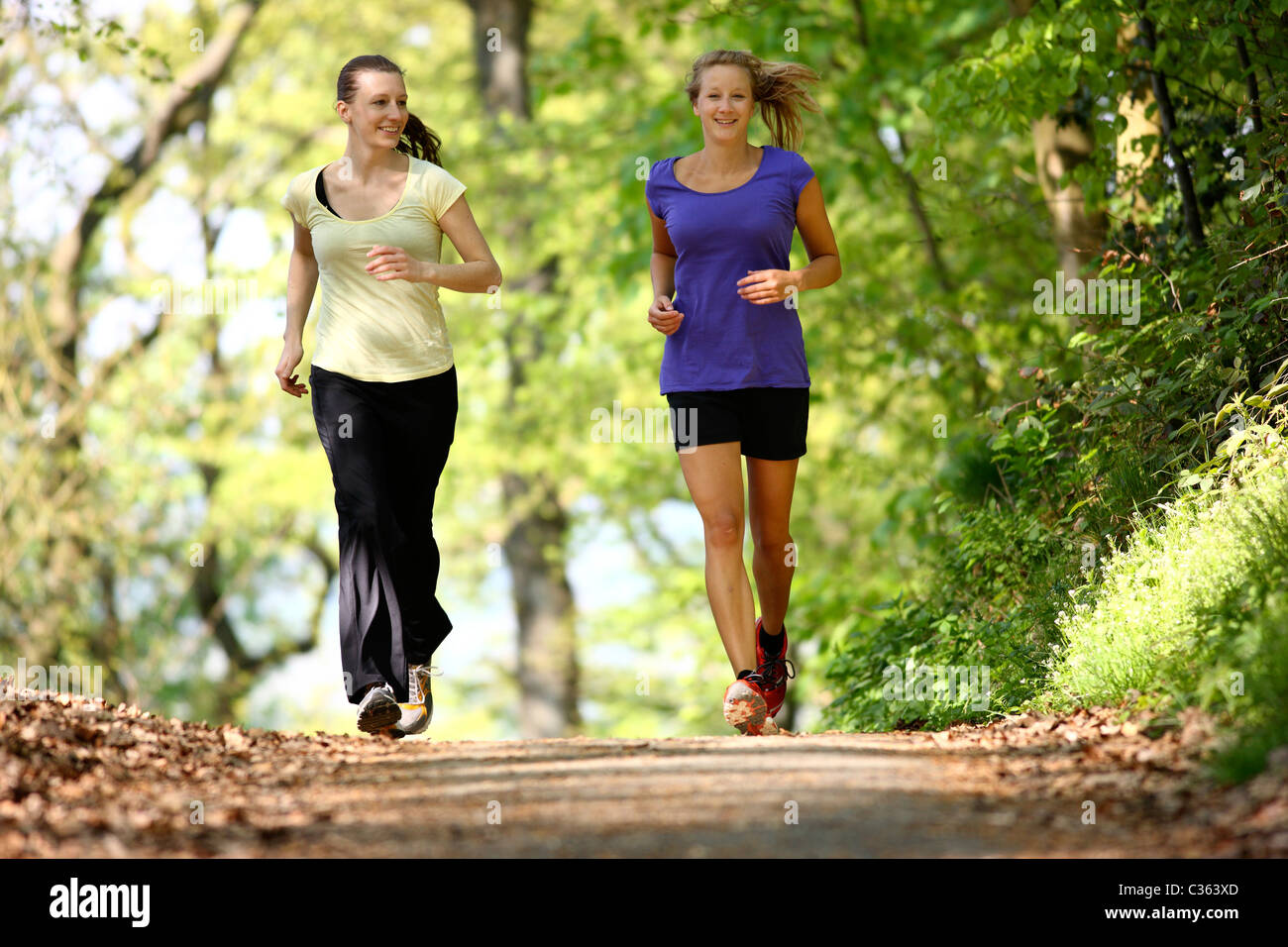 Two female hobby runners, jogging in a forest in summer Stock Photo - Alamy