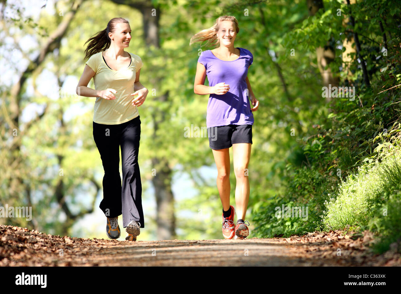 Two female hobby runners, jogging in a forest in summer Stock Photo - Alamy