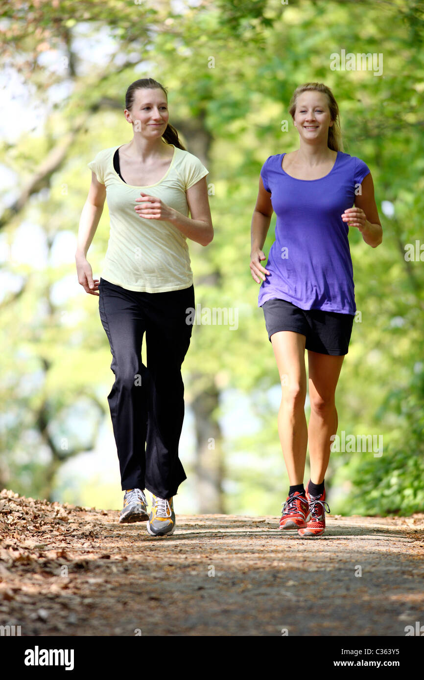 Two female hobby runners, jogging in a forest in summer Stock Photo - Alamy
