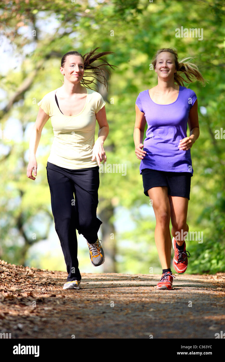 Two female hobby runners, jogging in a forest in summer Stock Photo - Alamy