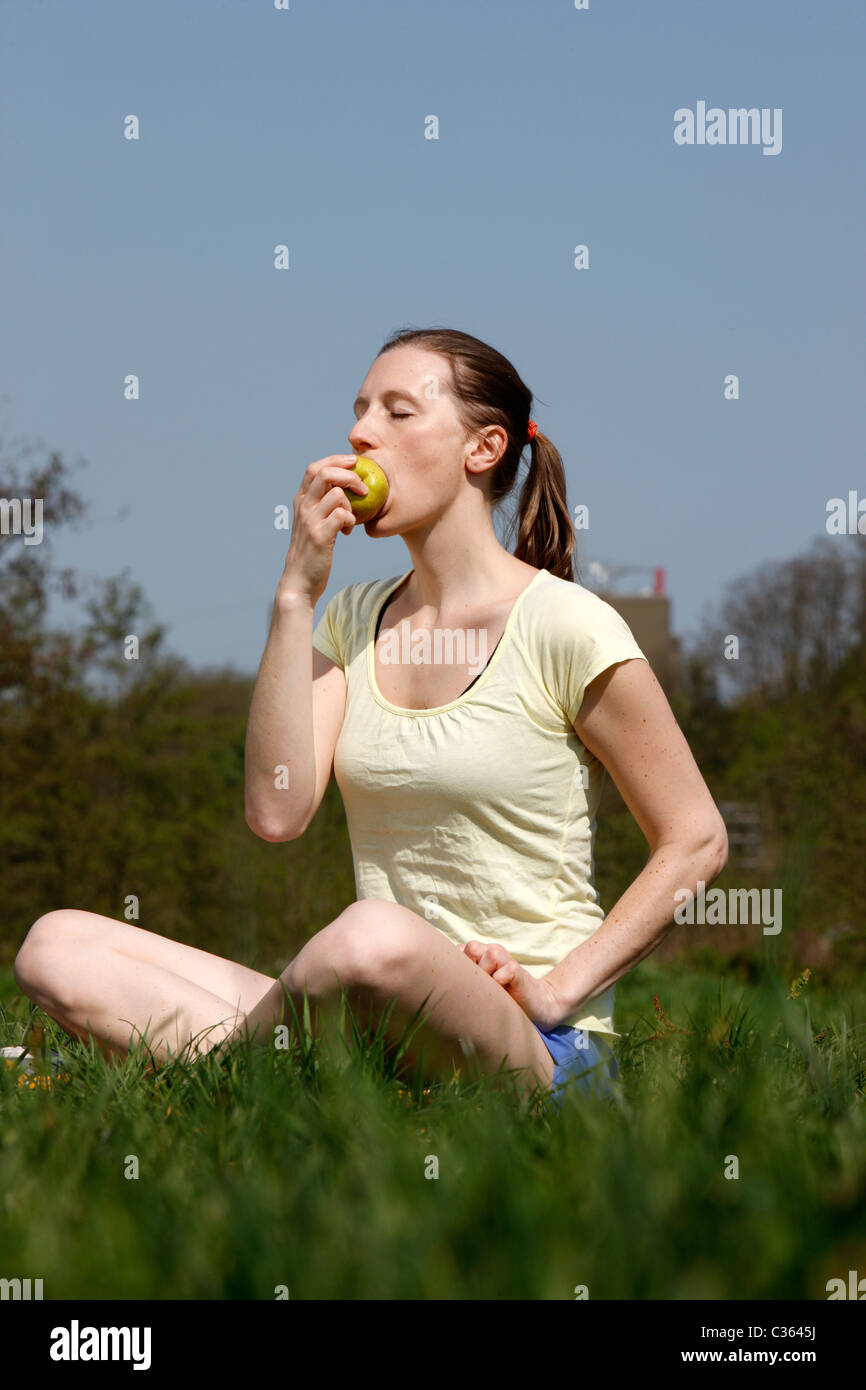 Young female hobby runner eats an apple after jogging exercise Stock ...
