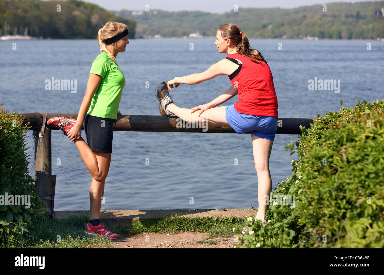 Two female hobby runners, stretching after jogging exercise Stock Photo ...