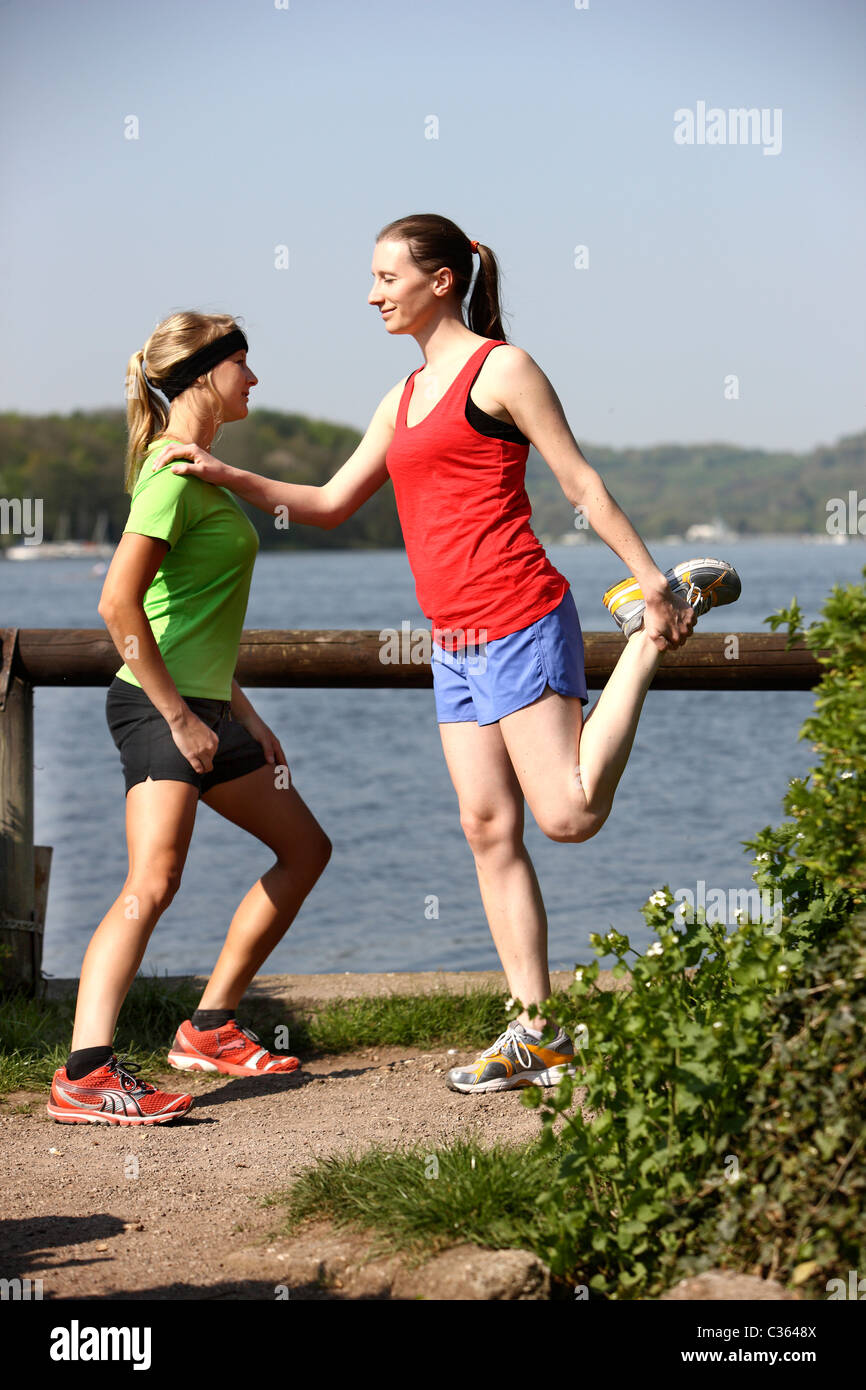 Two female hobby runners, stretching after jogging exercise Stock Photo ...