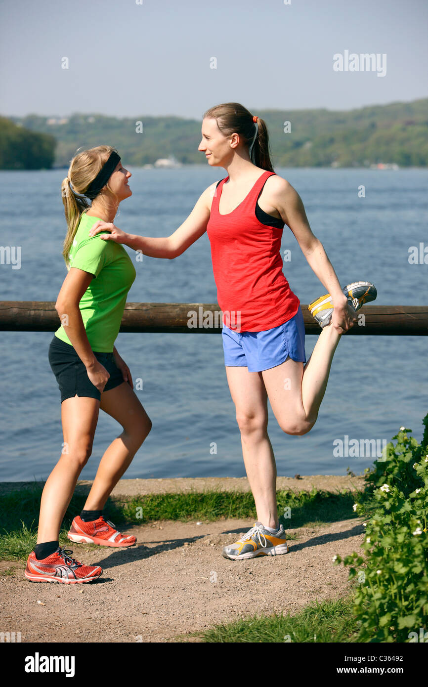 Two female hobby runners, stretching after jogging exercise Stock Photo ...