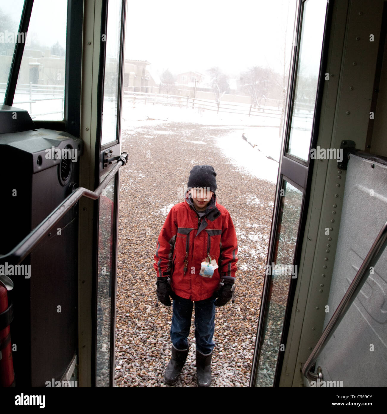 School age boy waiting for the bus. Boy in red coat standing in the ...