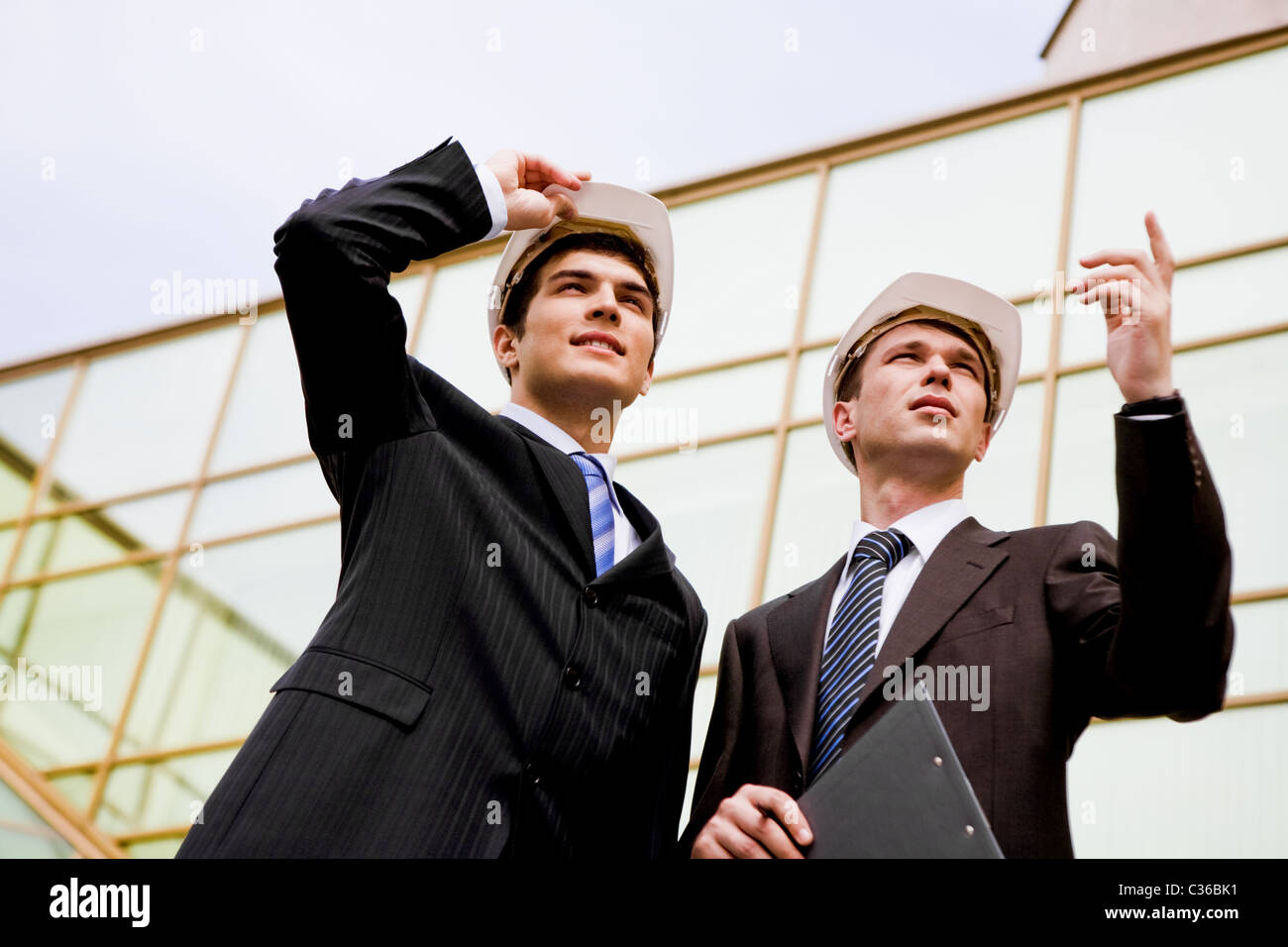 Photo of two co-workers discussing work while one of them showing ...