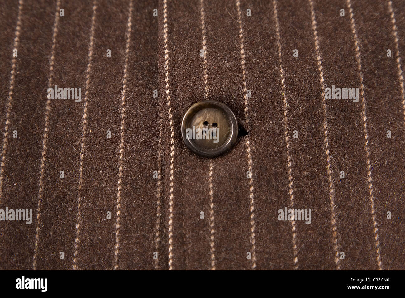 front view of classic striped fabric with close-up of brown button ...