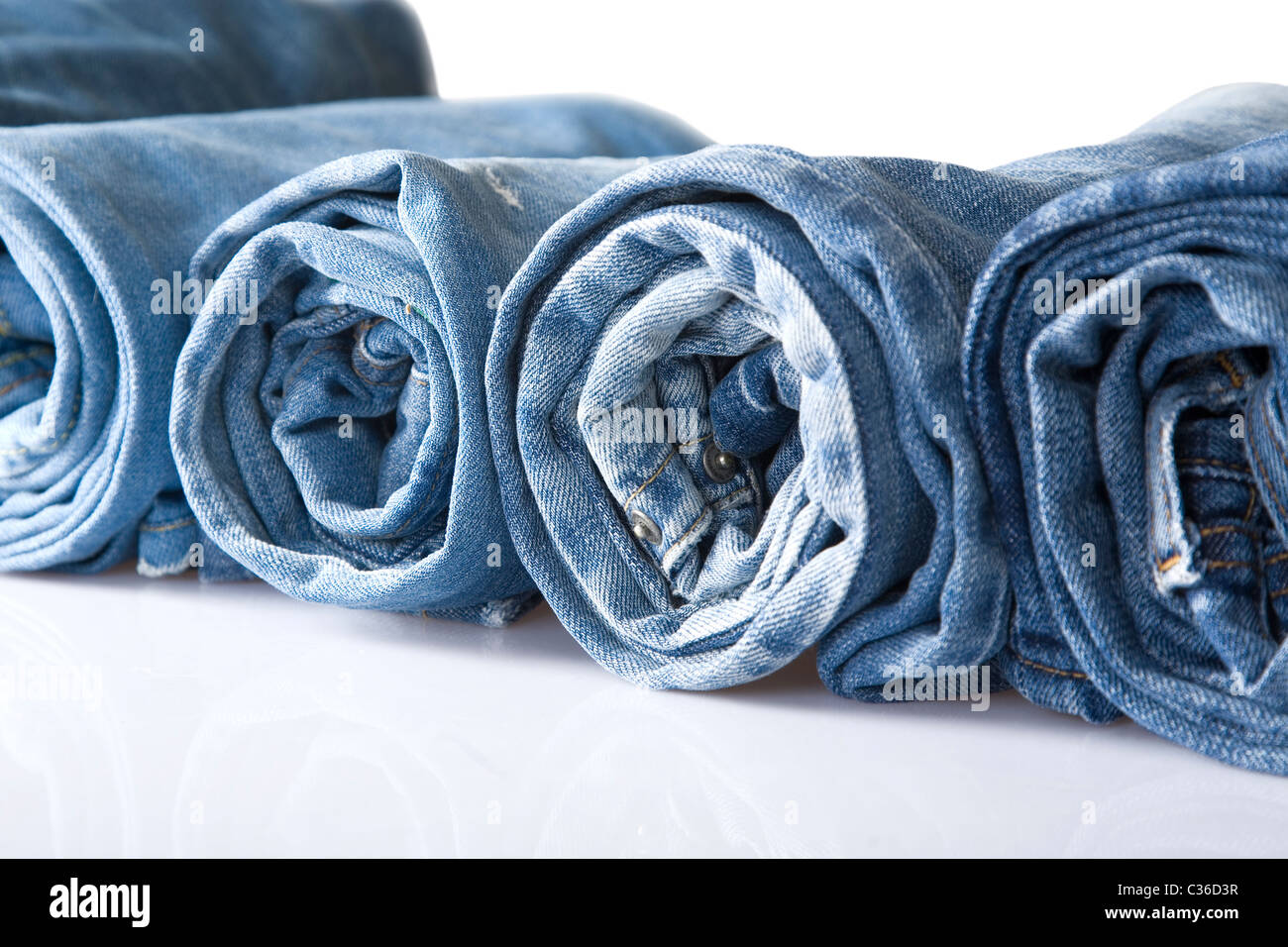 roll blue denim jeans arranged in line, isolated on white Stock Photo ...