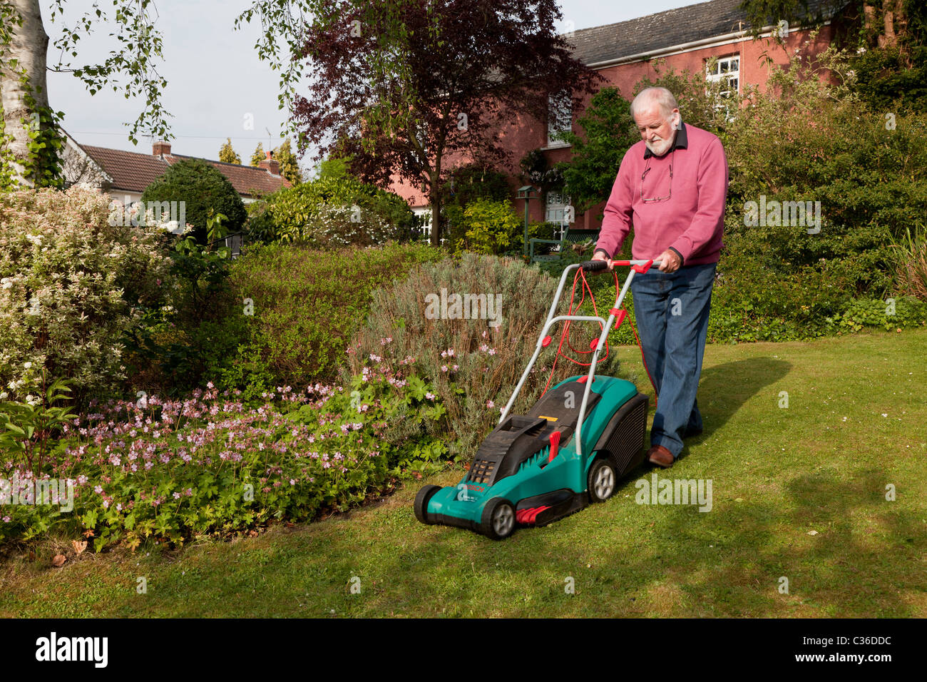 OLDER MAN MOWING LAWN WITH ELECTRIC MOWER UK Stock Photo - Alamy