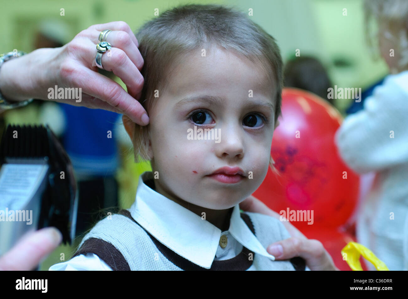 Shalev, Young Jewish boy of three having his first ritual haircut ...