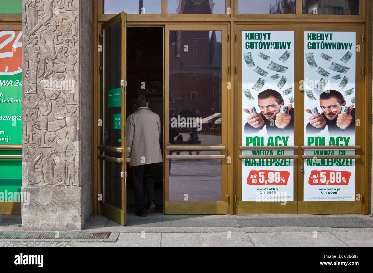 Customer entering bank, poster with actor Antonio Banderas surrounded ...