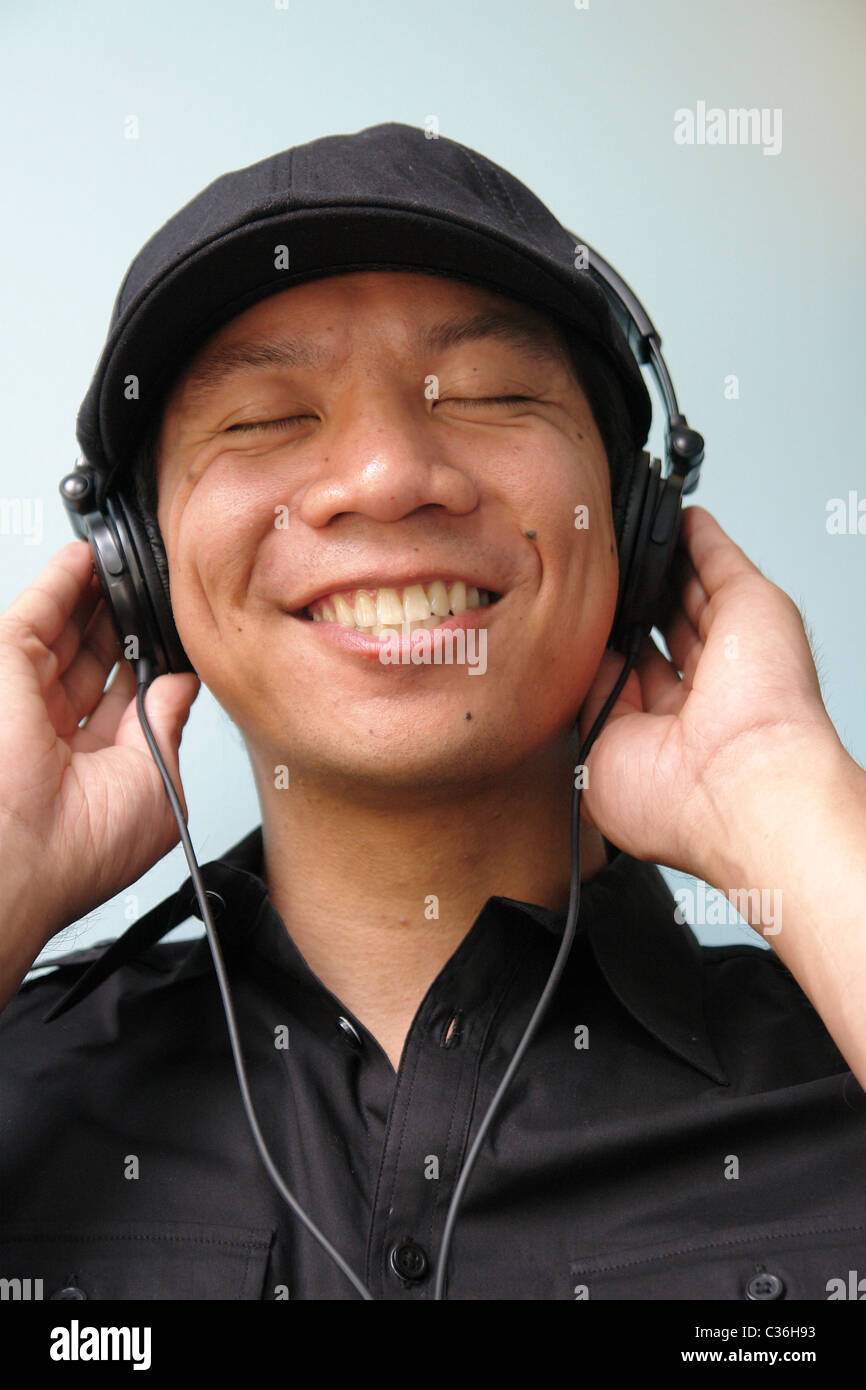 Studio Portrait Of Man Listening To Headphones With His Eyes Closed He