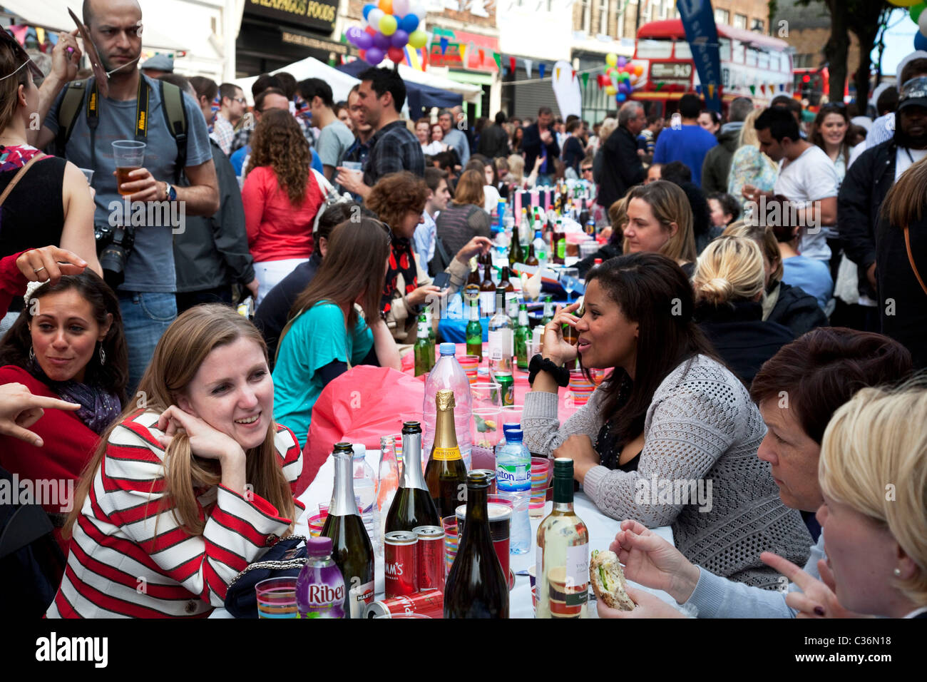 Eating and drinking on long communal tables at a street party on ...