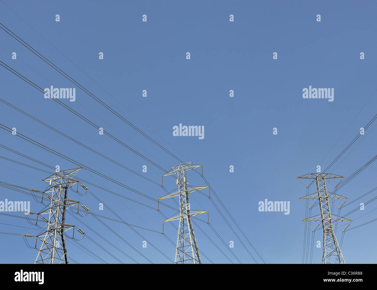 Electric wires on three tall metal transmission towers with electrical ...