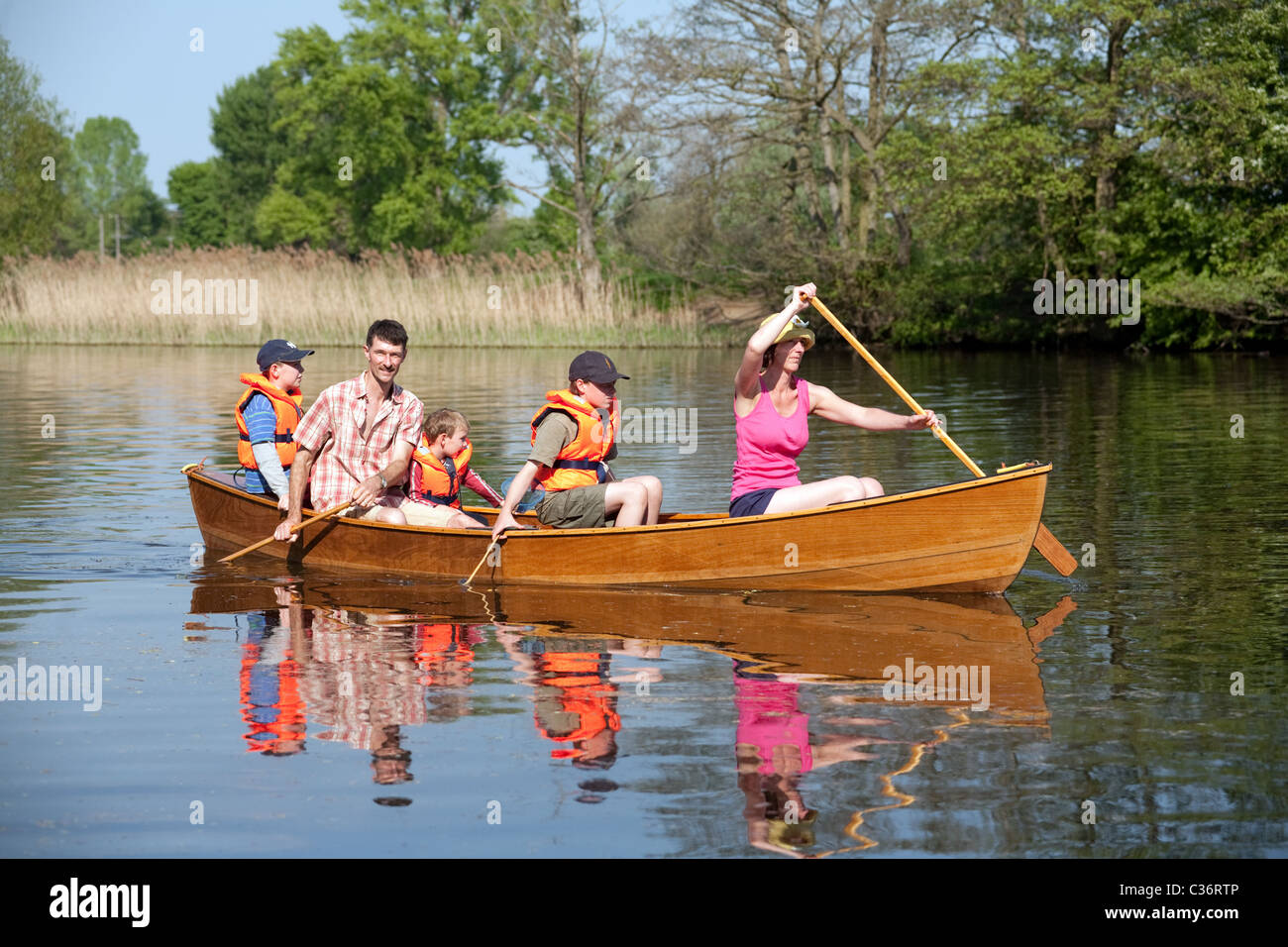 A family rowing a boat on the River Thames in summer, at Wallingford ...