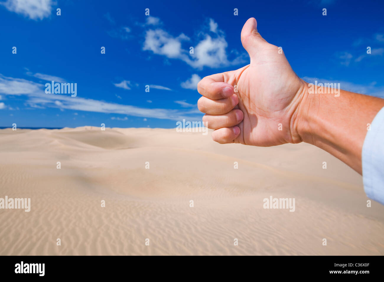 Thumbs up sign with sand dunes in the background Stock Photo - Alamy