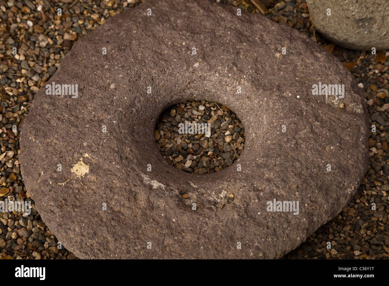 Severely worn Sinagua Indian metate (or mealing stone) at the entrance ...