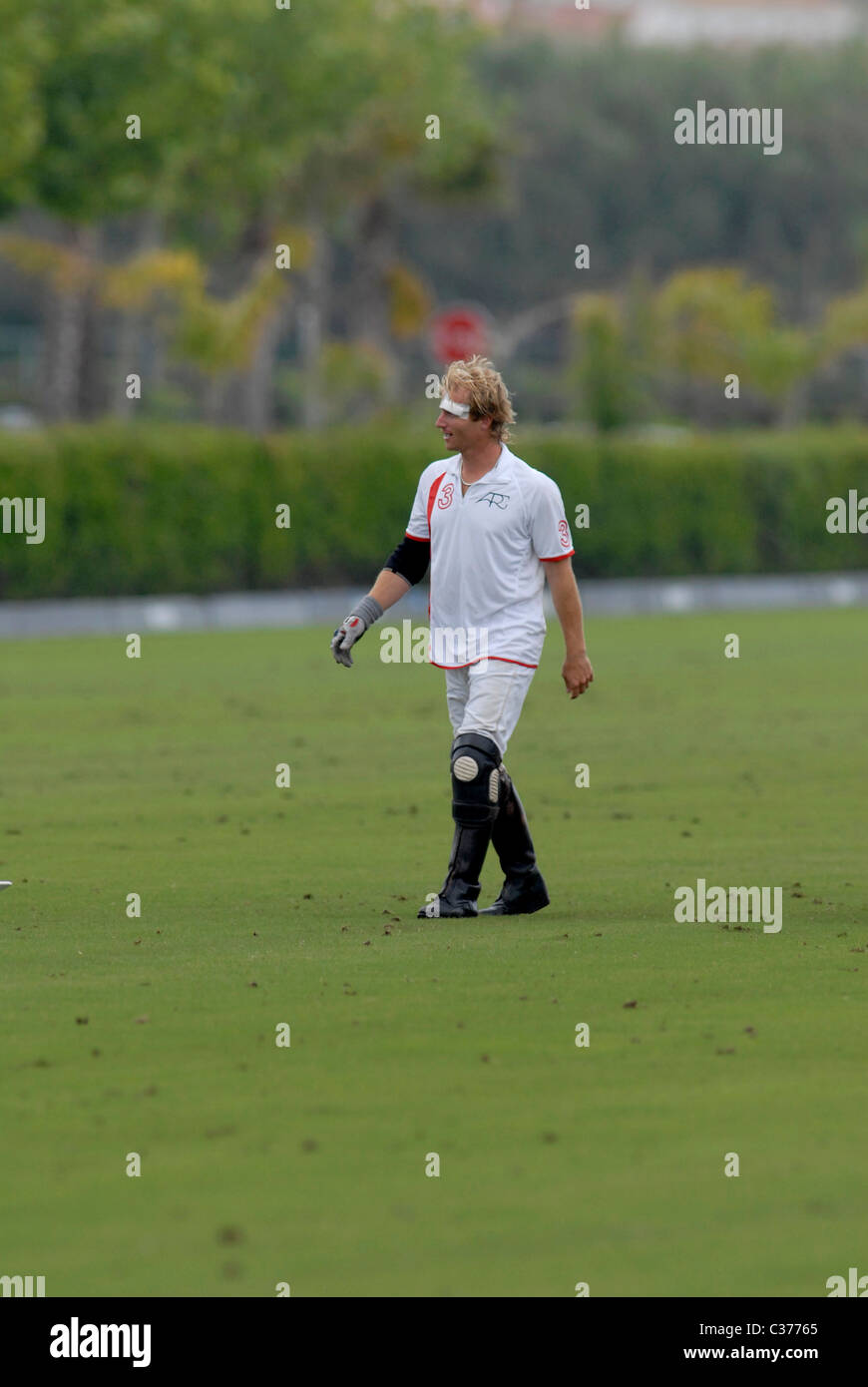 Polo player walking across polo field after receiving treatment for ...