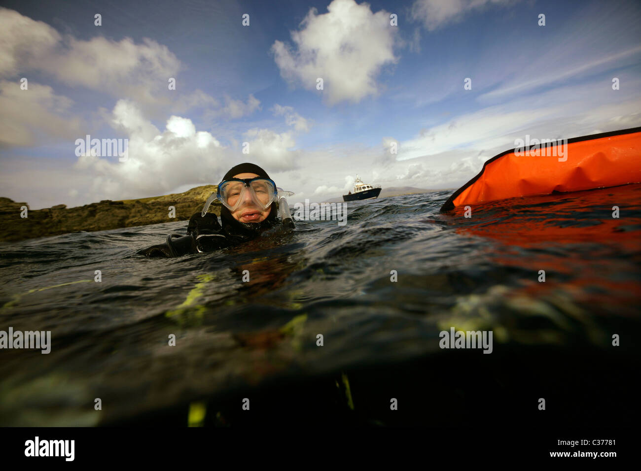 A diver on the surface waits to be picked up by the approaching dive ...