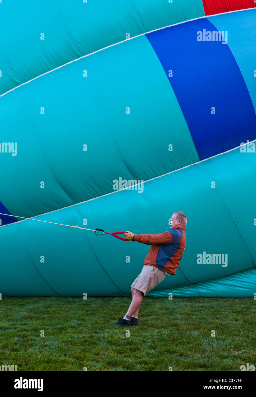 A crew member helps control the balloon as it get's set up. Hot air ...