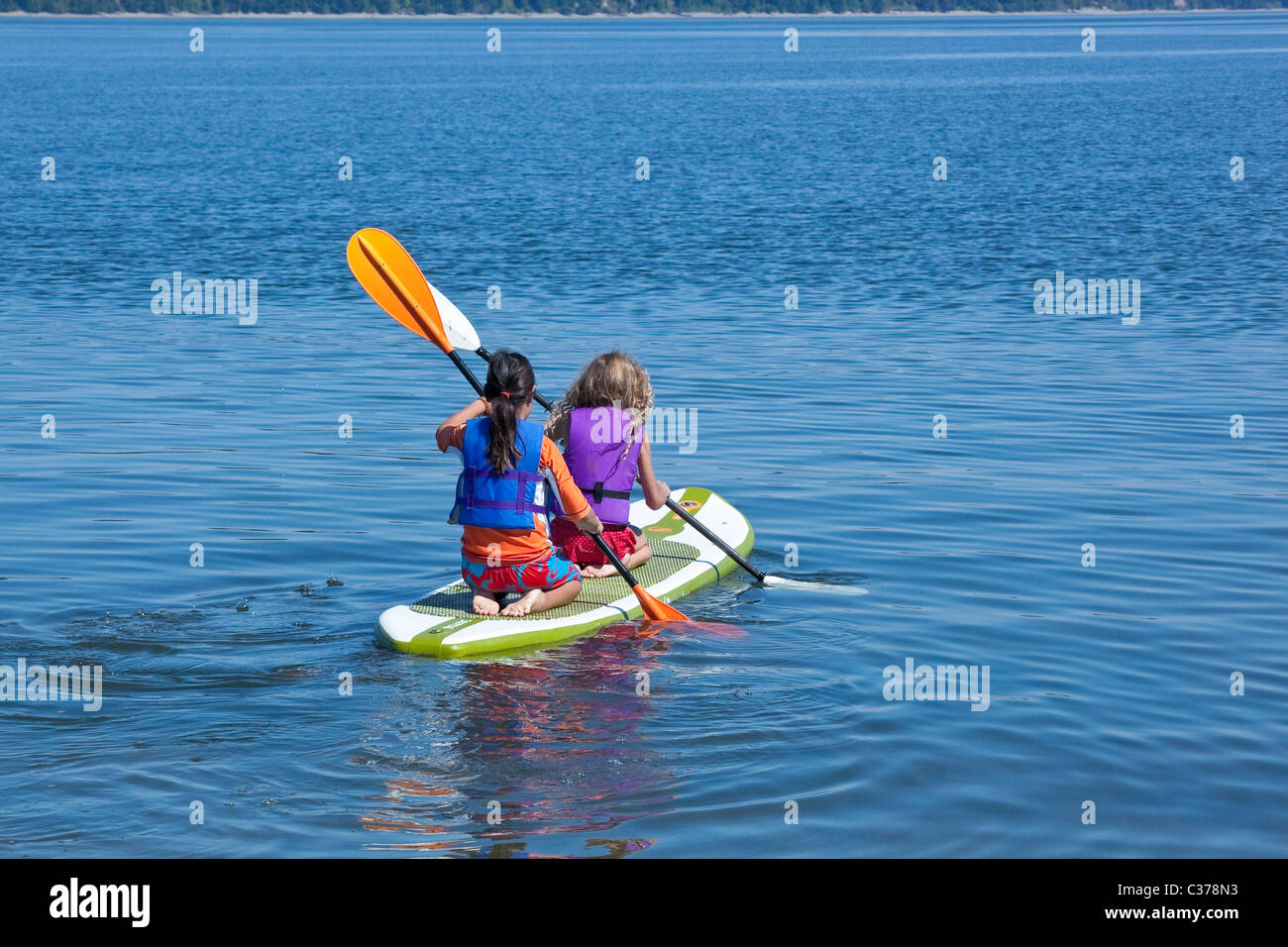 girls on paddle board in lake Stock Photo - Alamy