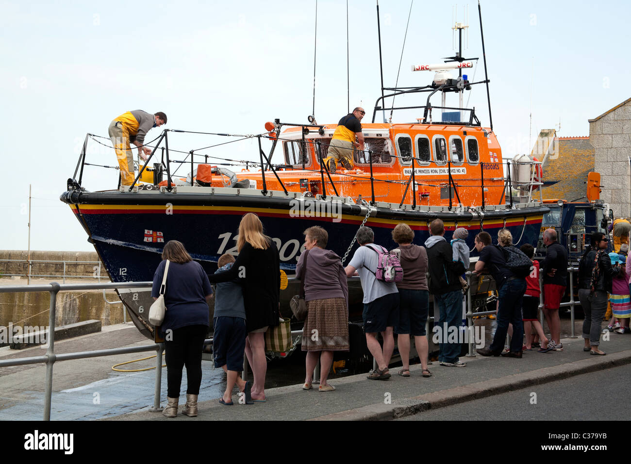 Tourists and locals watching the lifeboat men clean the lifeboat after ...