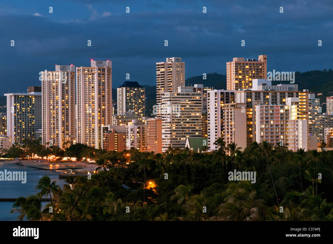 A high angle twilight view of Kapiolani Beach Park and the high-rise ...