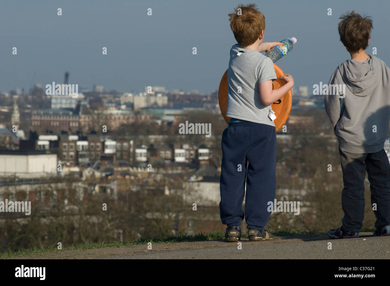 two young boys pointing at buildings in the distance at Primrose hill ...
