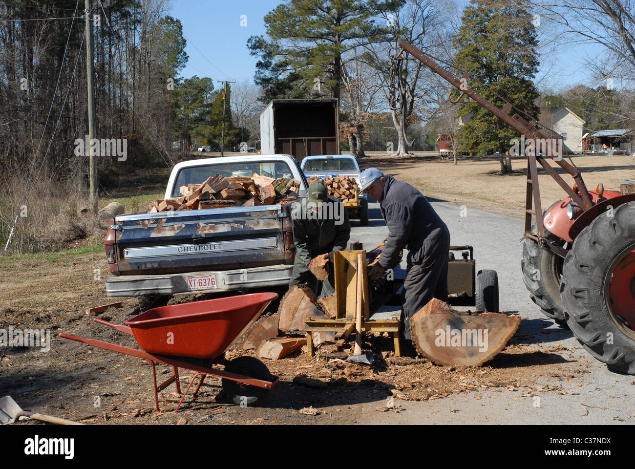 Men splitting logs on a log splitter for firewood Stock Photo - Alamy
