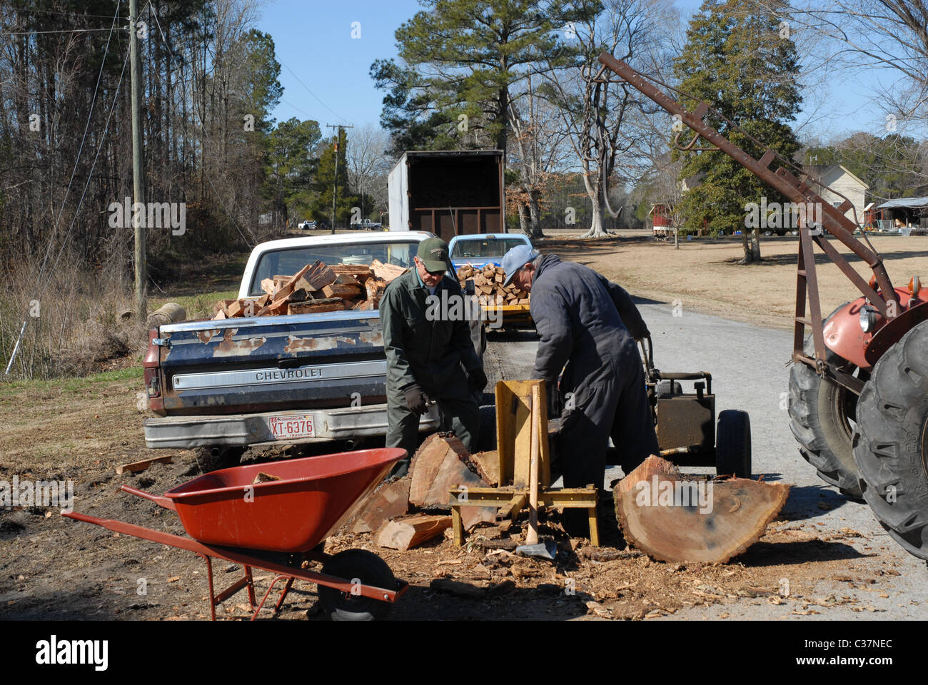 Men splitting logs on a log splitter for firewood Stock Photo - Alamy
