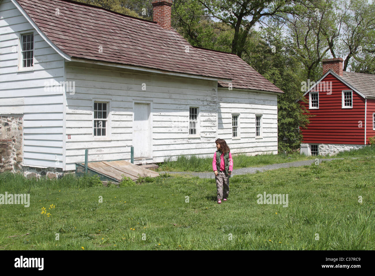 Young Girl walking by White Old Style Cottage Stock Photo - Alamy