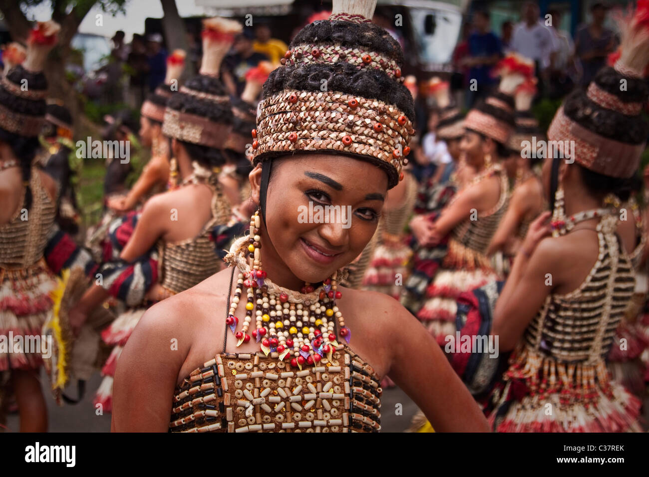 A portrait Filipina street dancer in full brown costume with head gear ...