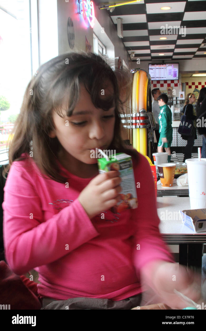 Young girl drinking out of a juice box Stock Photo - Alamy