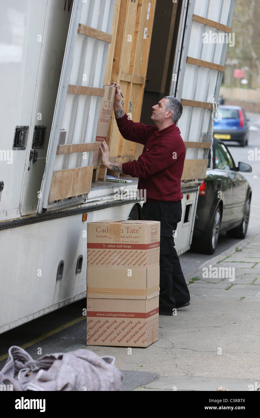 Movers are seen loading boxes and furnitures into a moving truck from ...