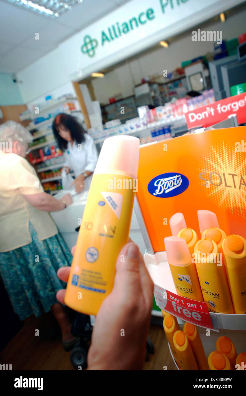 A Boots customer selecting a bottle of special offer sun lotion Stock ...
