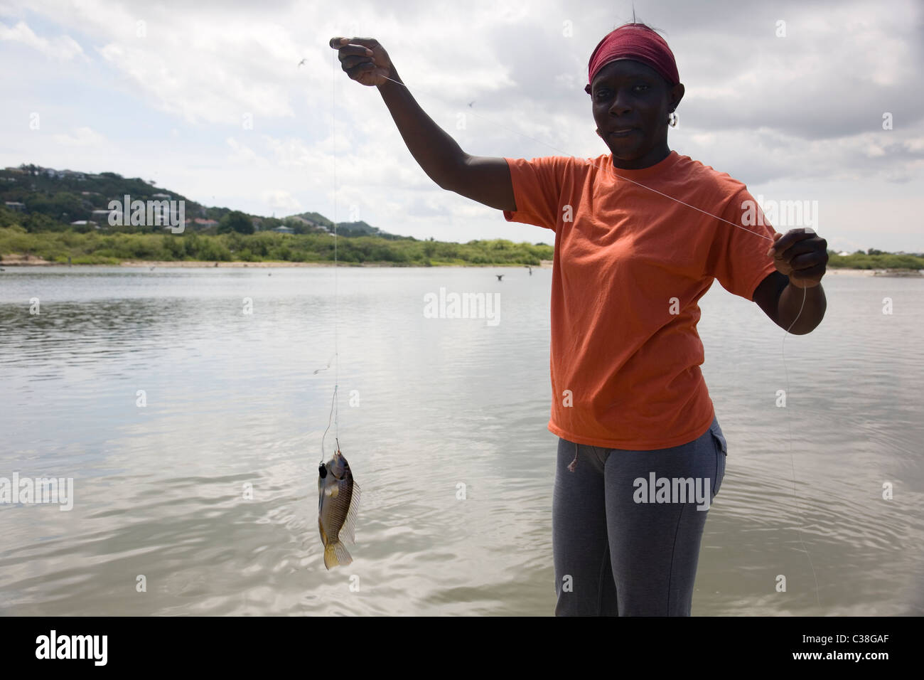 Woman holding fish caught at McKinnons Pond in Antigua Stock Photo - Alamy