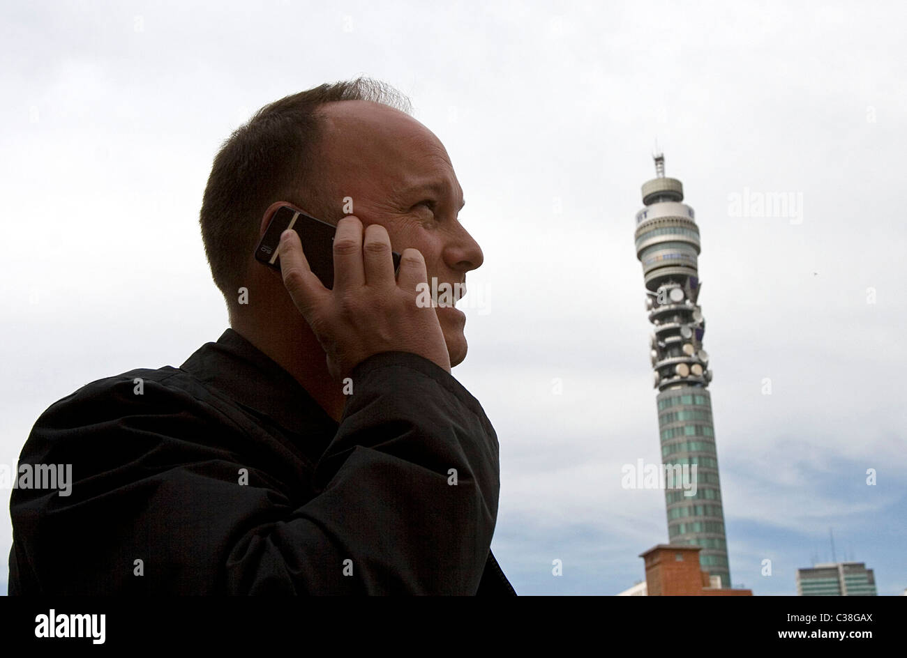 A man talks on his mobile while the BT Tower is visible in the ...
