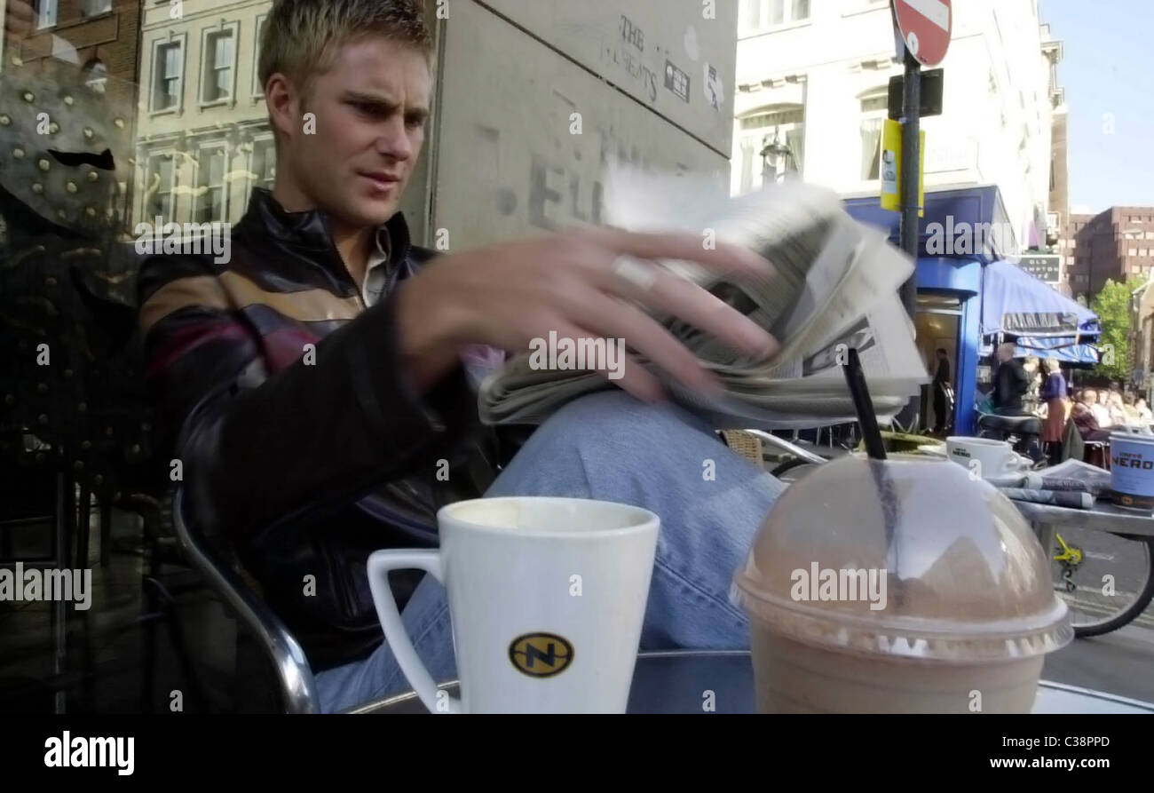 A man reading a newspaper outside a Caffe Nero store Stock Photo - Alamy