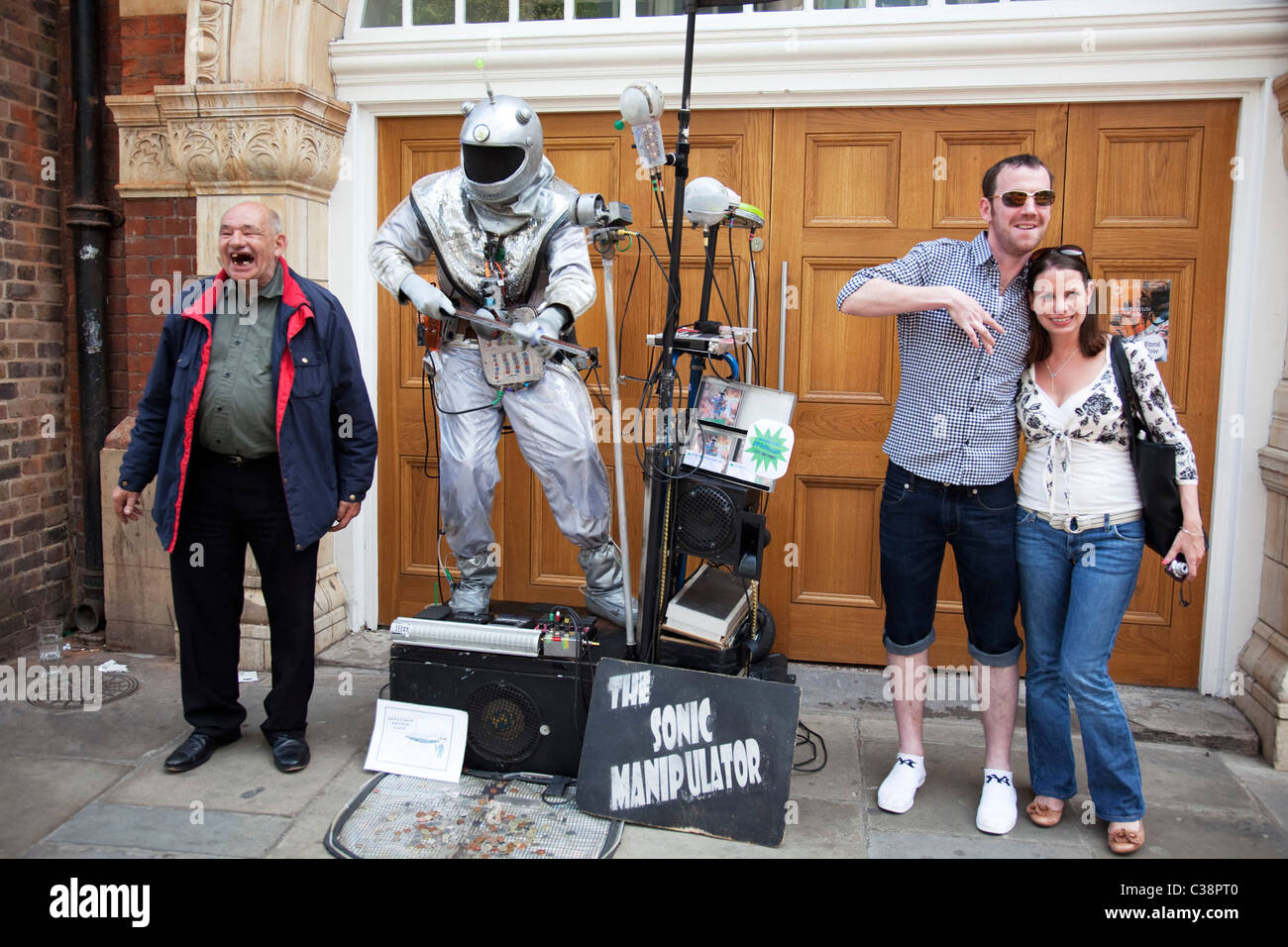Busker / street performer dressed up as a space man, performing his ...