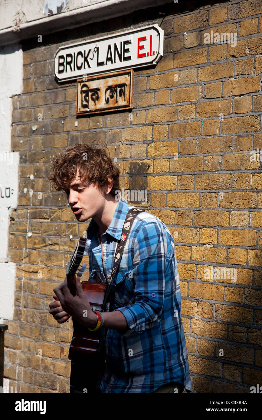Brick Lane in the East End of London. Musicians busking underneath the ...