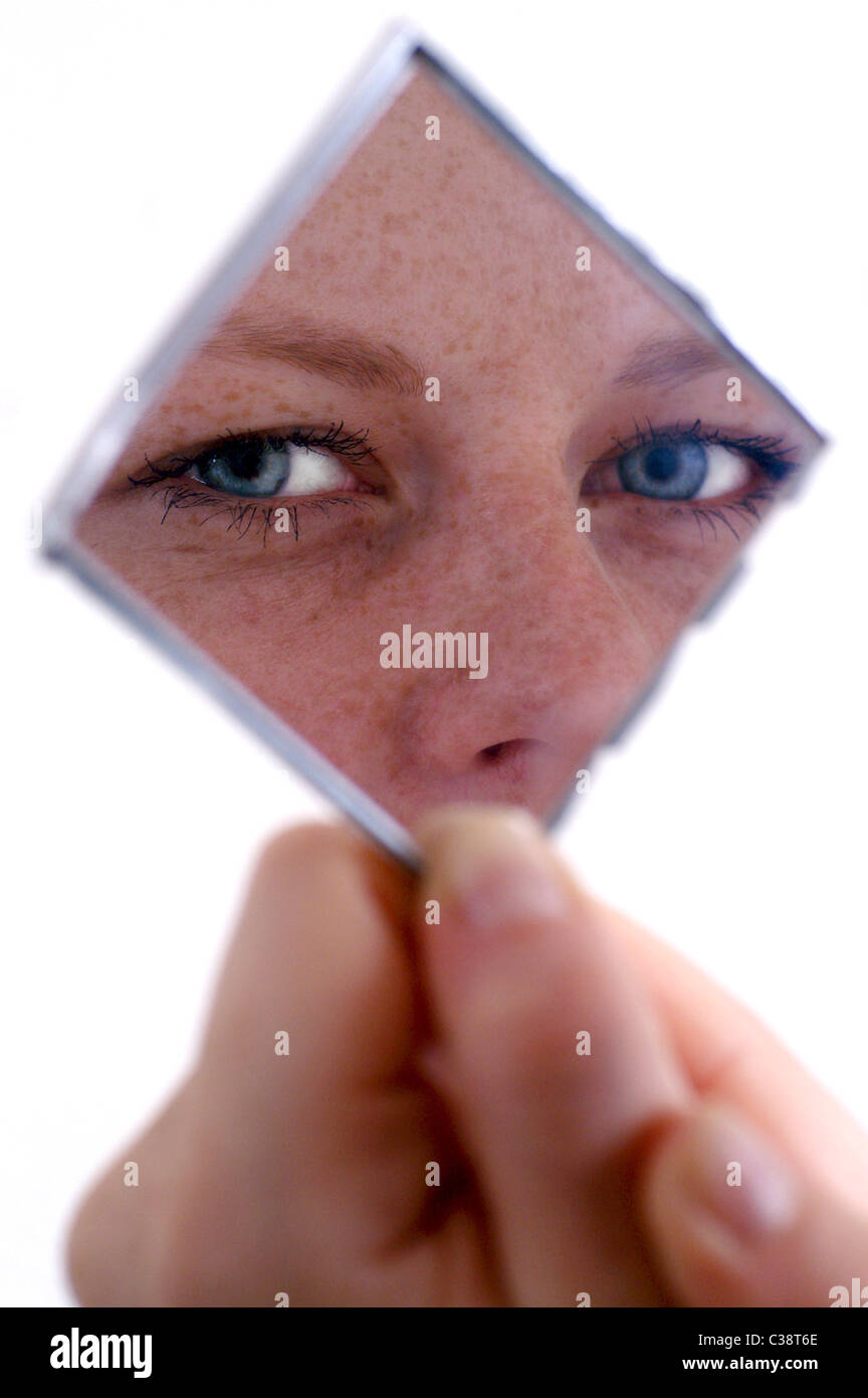 A young woman looking through a pocket sized mirror Stock Photo - Alamy