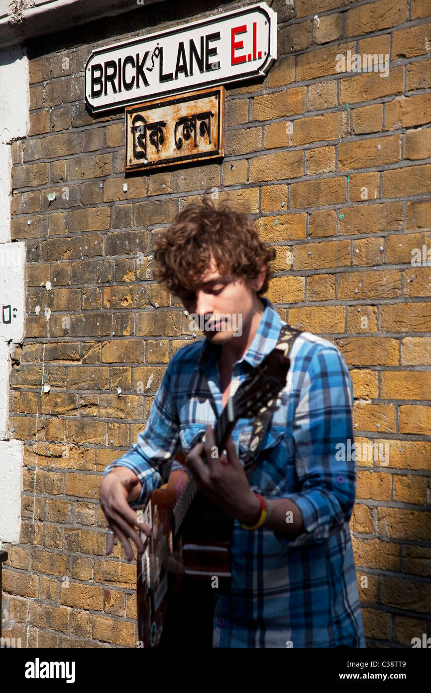 Brick Lane in the East End of London. Musicians busking underneath the ...