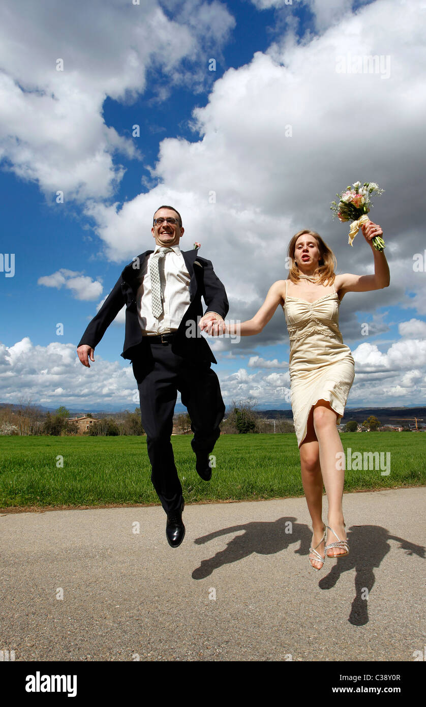 Married couple celebrate by jumping into the air Stock Photo - Alamy