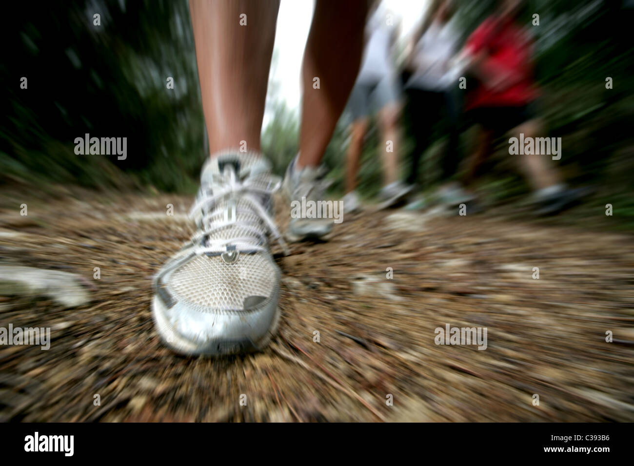 Close up of foot in motion as it strikes the ground as adults walk ...