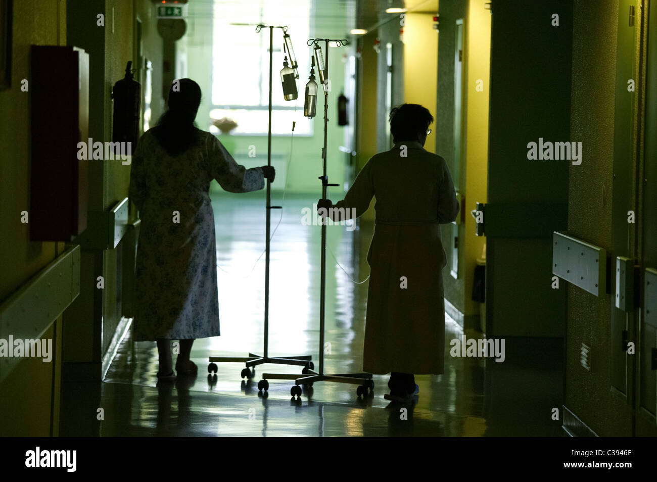 Silhouettes of two patients walking in hospital corridor Stock Photo ...